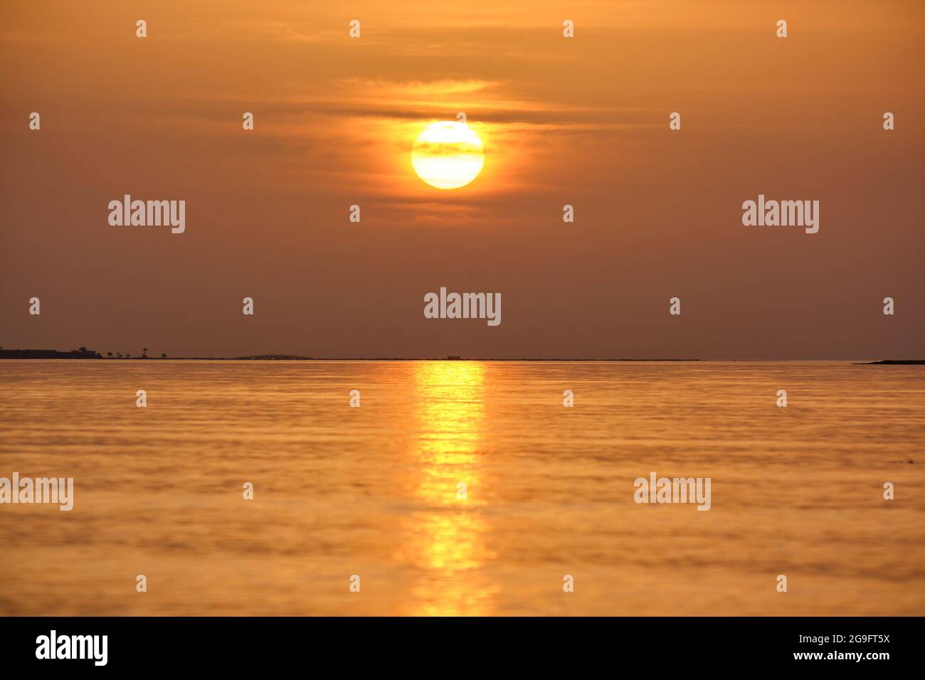 Big yellow sun setting down over sea surface Stock Photo - Alamy