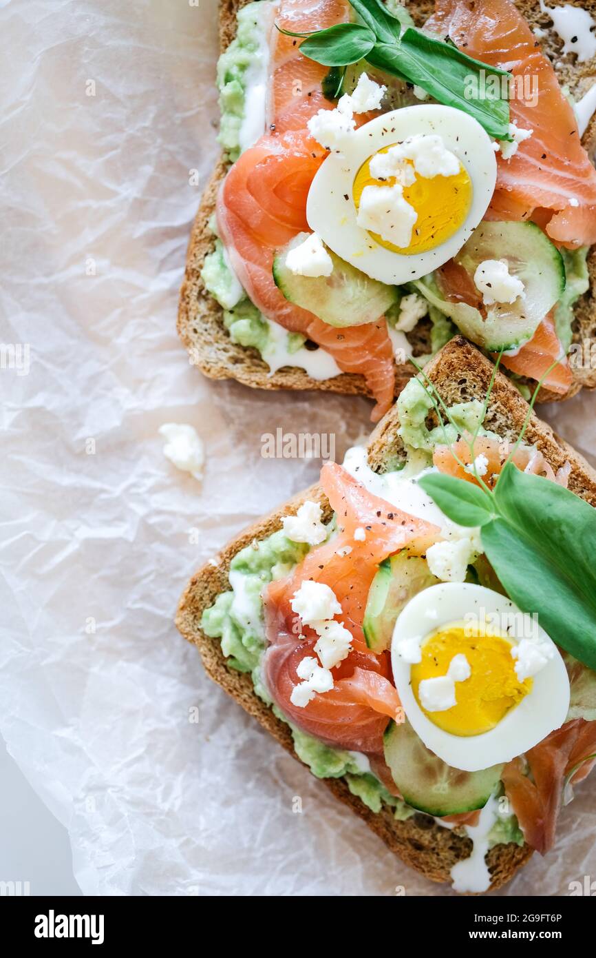 Open sandwich traditional danish smorrebrod salmon, cucumber, boiled egg, soft cheese. Homemade ...