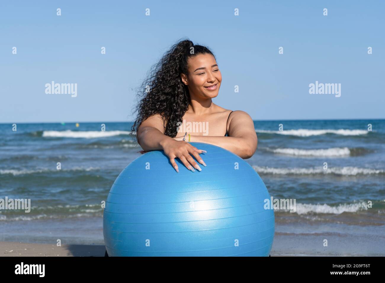 Woman sitting on beach ball hi-res stock photography and images - Alamy