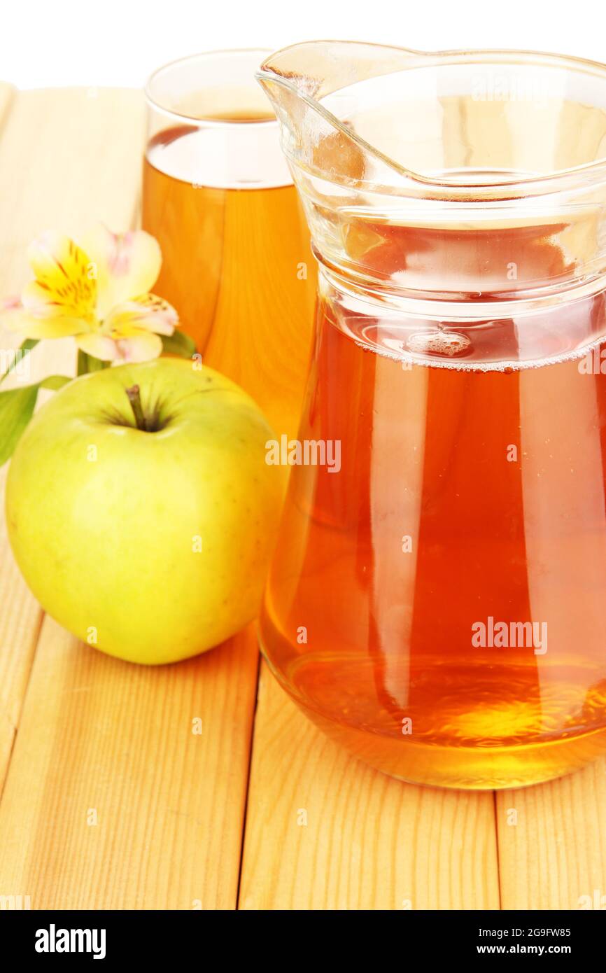 Full glass and jug of apple juice and apples on wooden table Stock ...