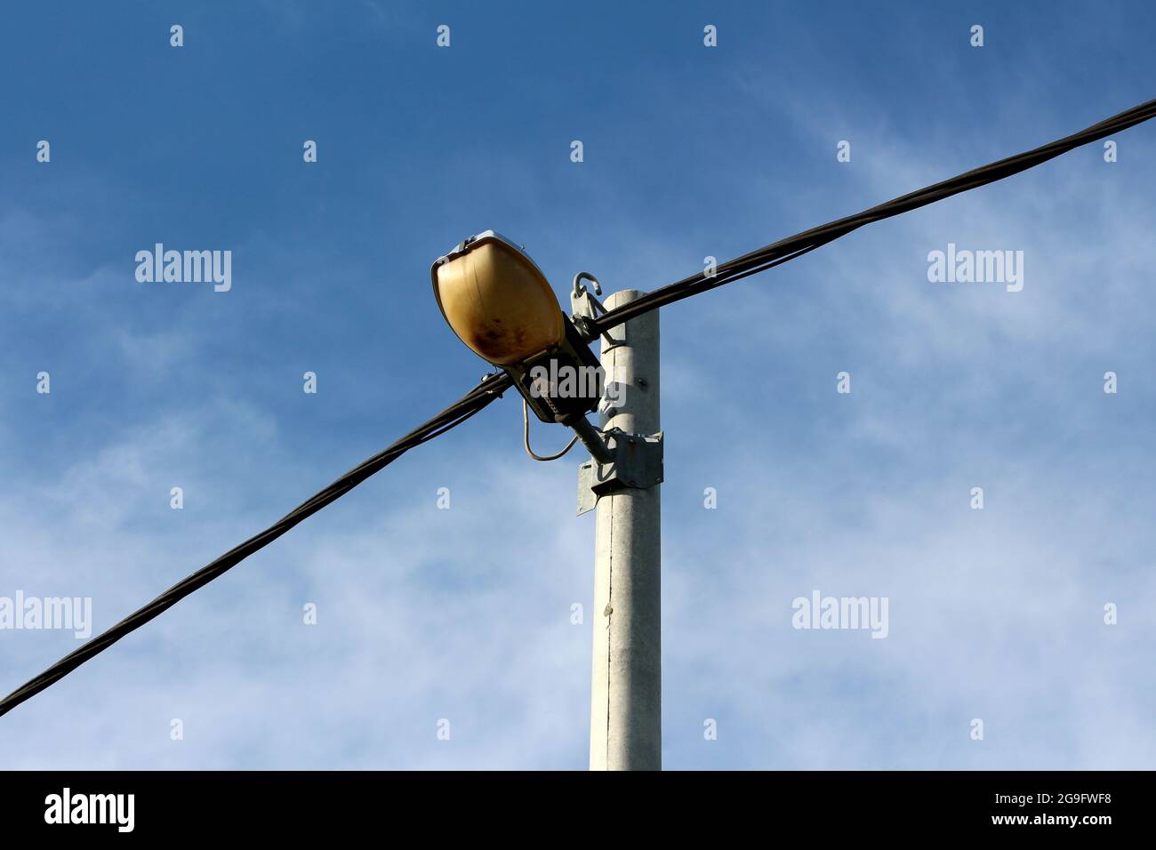 Concrete electrical utility pole with thick black electrical wires and ...