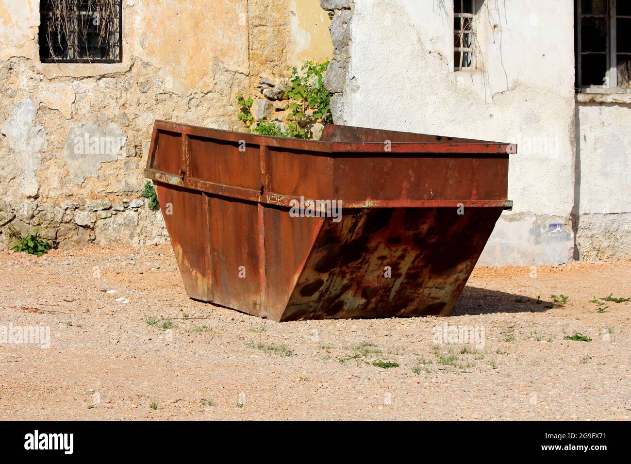 Heavily used old large rusted industrial recycling container left on ...