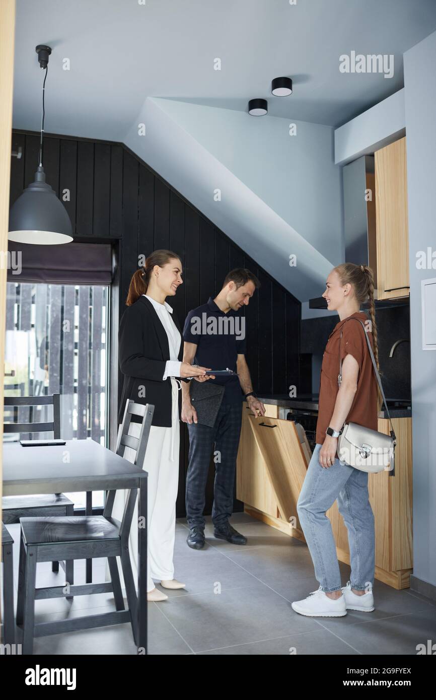 Vertical full length portrait of smiling real estate agent showing ...