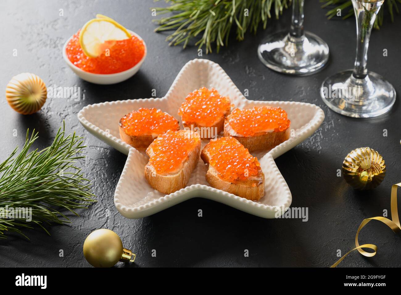 Russian appetizer canape with red caviar on ciabatta on black ...
