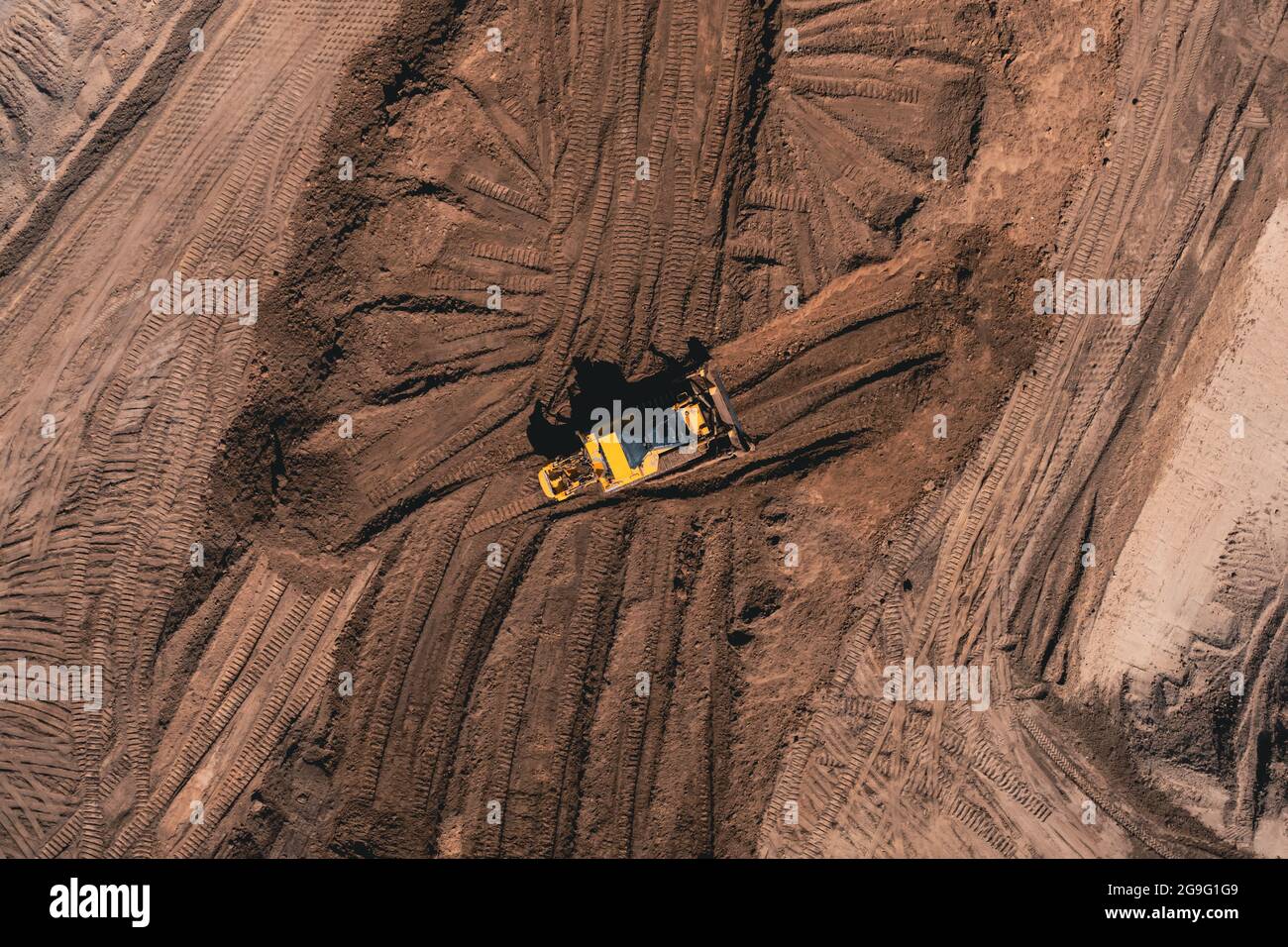 Yellow Bulldozer carries out excavation work in a clay quarry - aerial ...