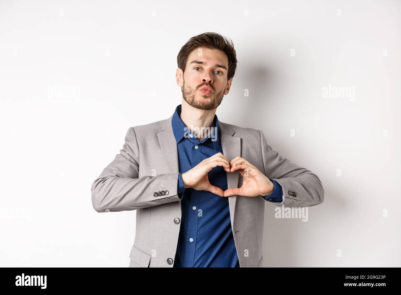 Romantic man in suit showing heart sign and pucker lips for kiss ...