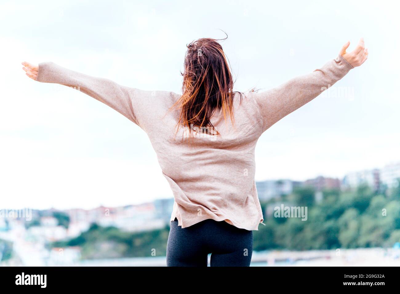 beautiful young adult woman with open arms smiling with feeling of ...