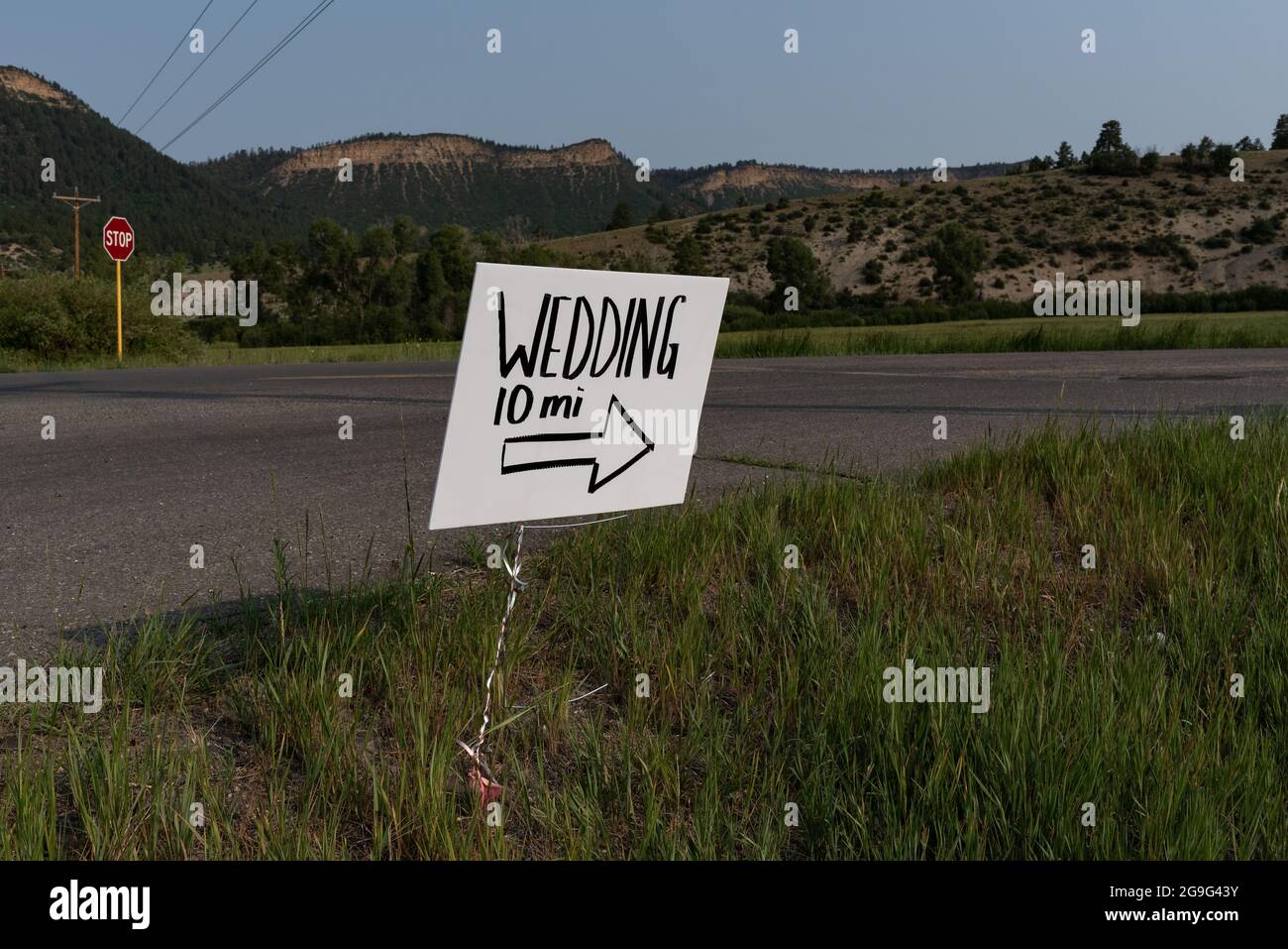 A handmade white sign with black lettering placed along a remote ...