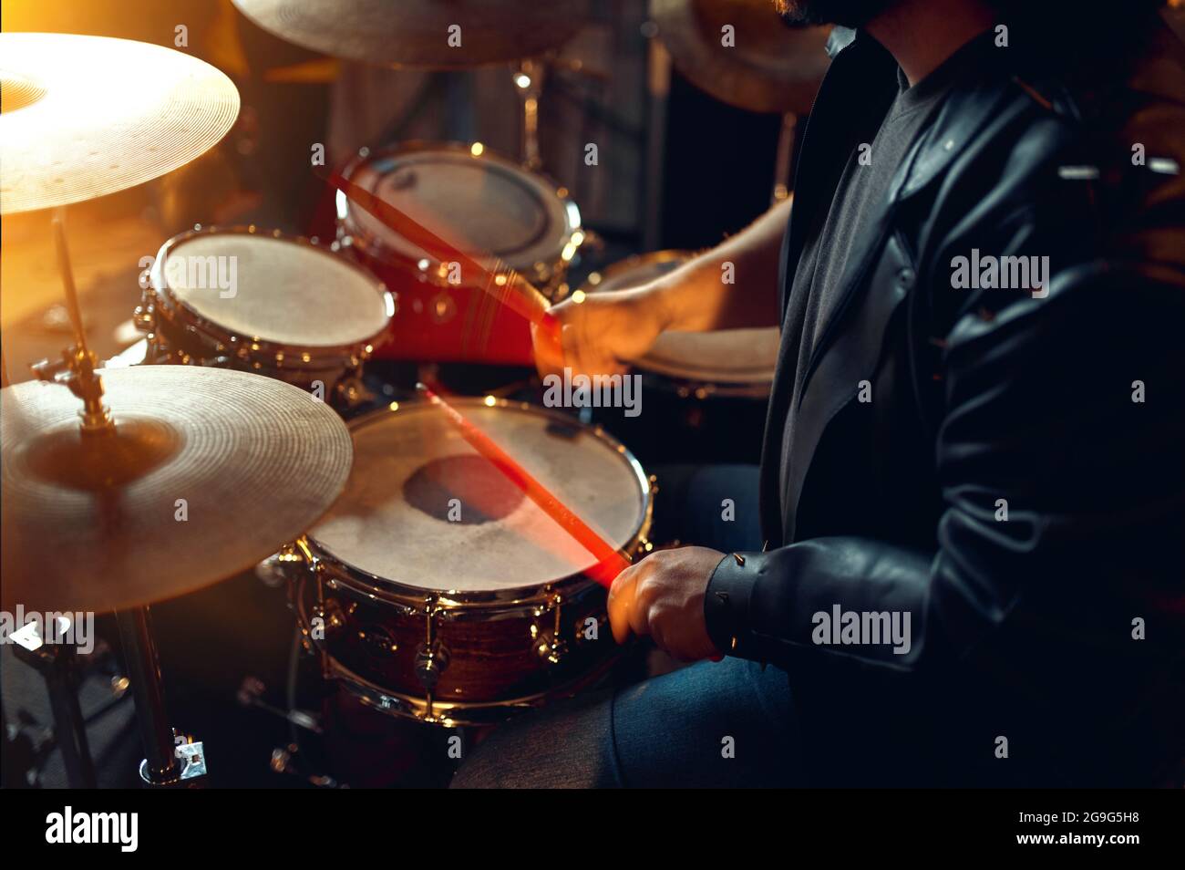 Brutal drummer behind the drum kit on stage Stock Photo - Alamy