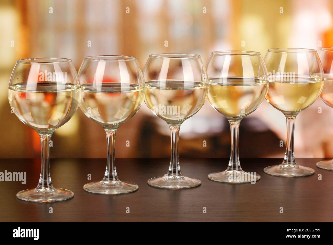 White wine in glass on room background Stock Photo - Alamy