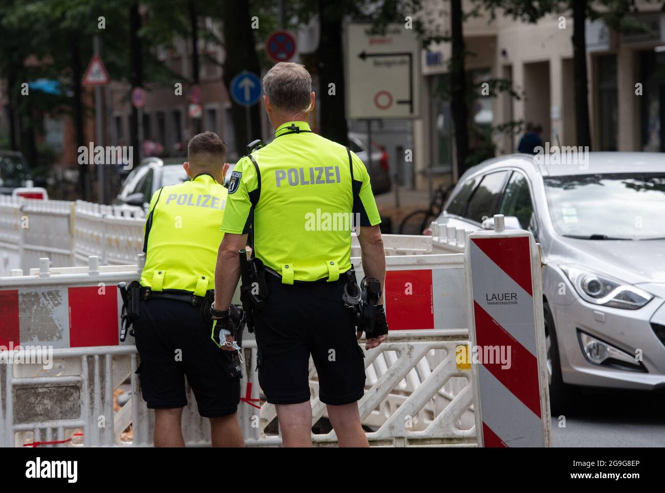 26 July 2021, Berlin: Officers of the Berlin police bicycle squad watch ...