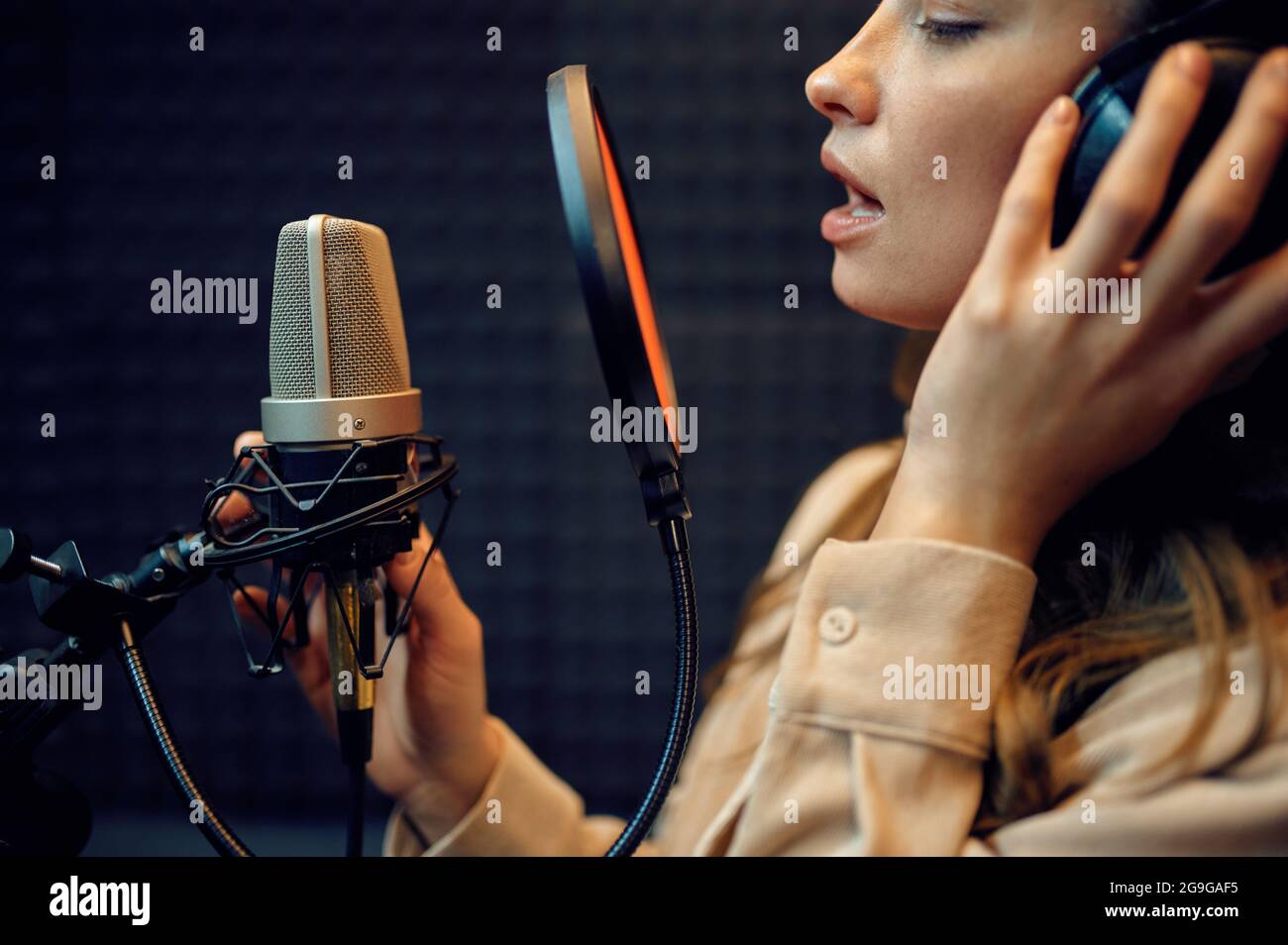 Female performer at micriphone, recording studio Stock Photo - Alamy