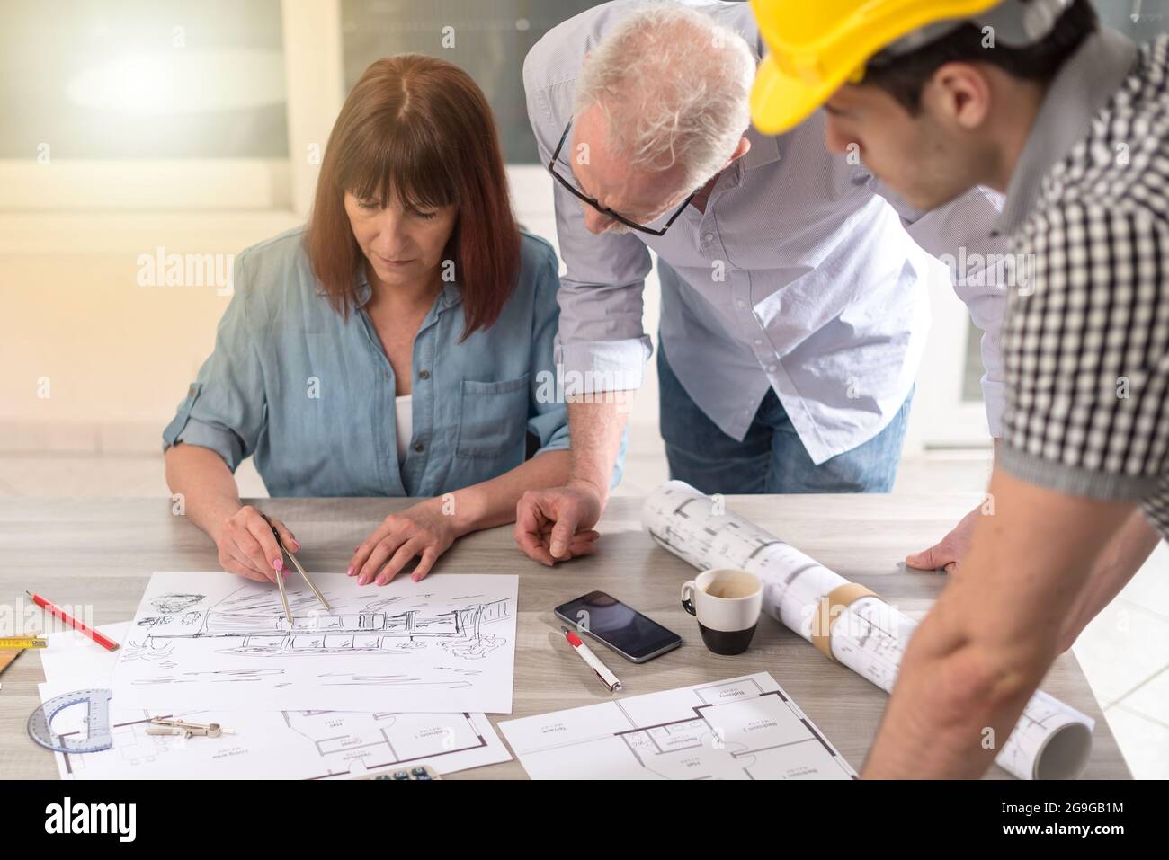 Architects working on plans at office, light effect Stock Photo - Alamy