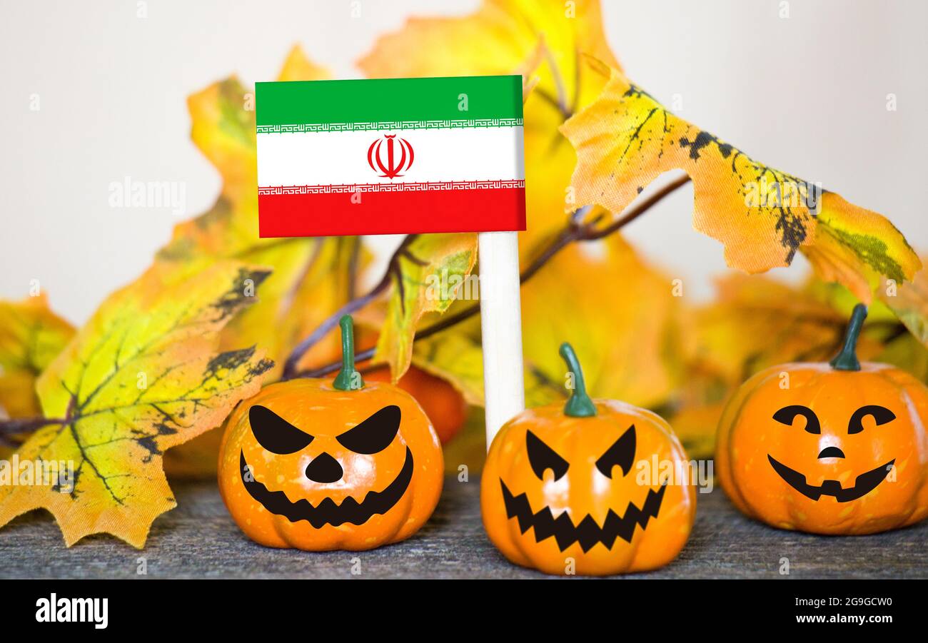 Colorful Halloween background with smiley pumpkins and toy flag of Iran ...