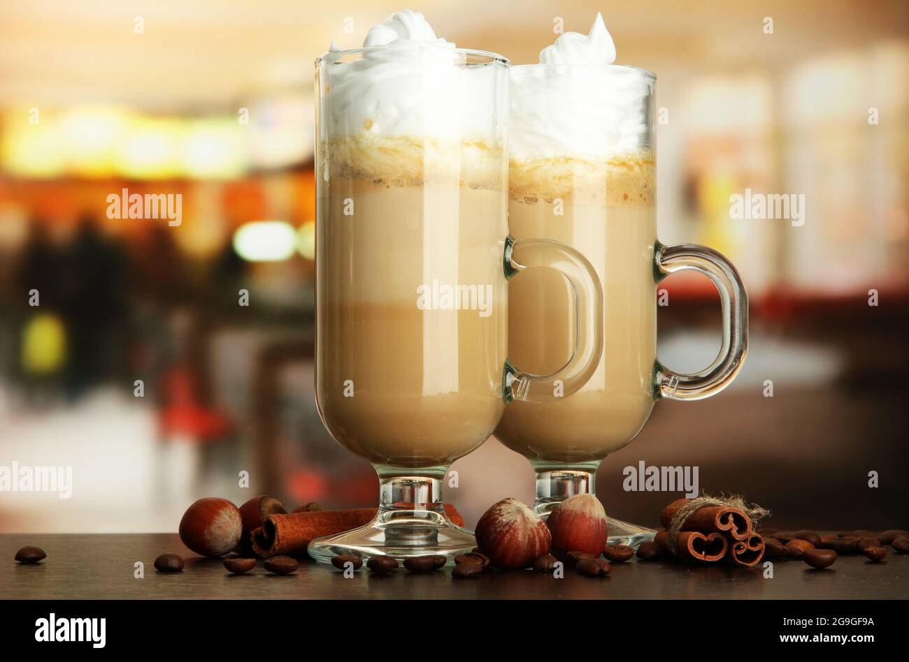 Fragrant coffee latte in glasses cups with spices, on table in cafe ...