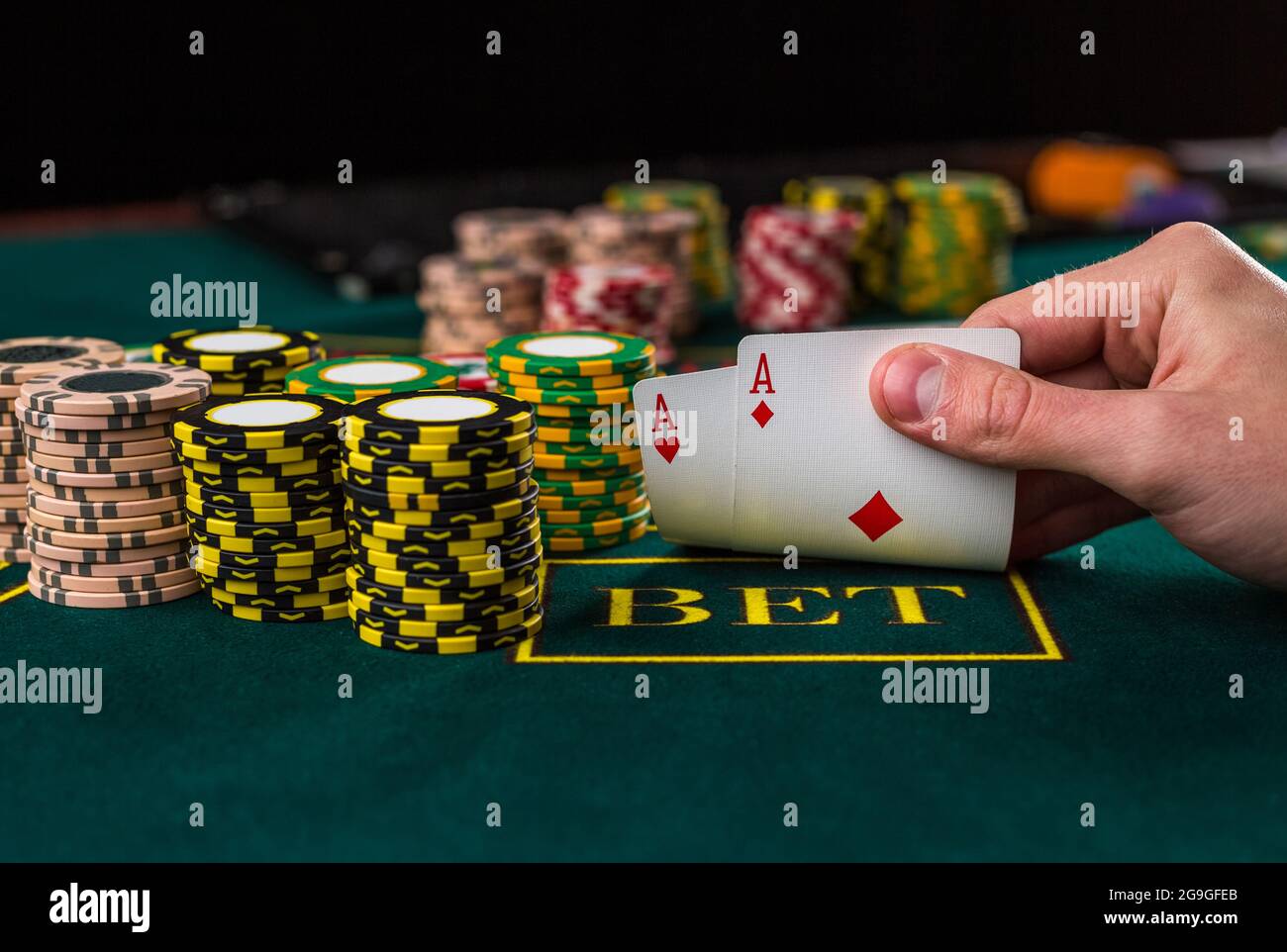 Male poker player lifting the corners of two cards aces Stock Photo - Alamy