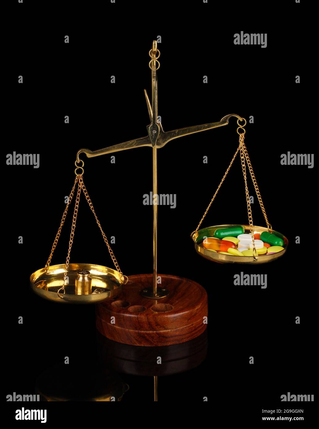 Classic scales with color pills isolated on black Stock Photo - Alamy