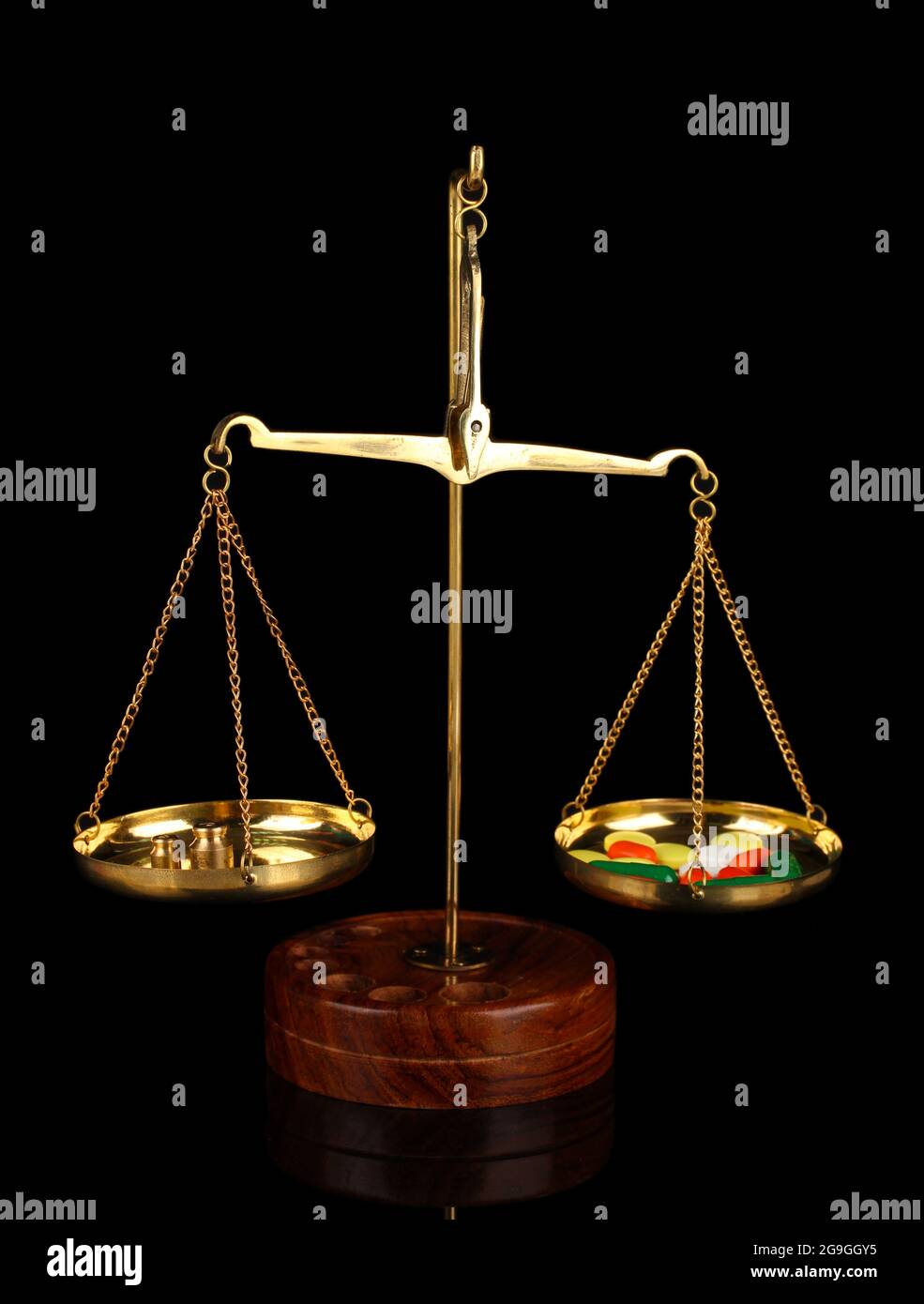 Classic scales with color pills isolated on black Stock Photo - Alamy