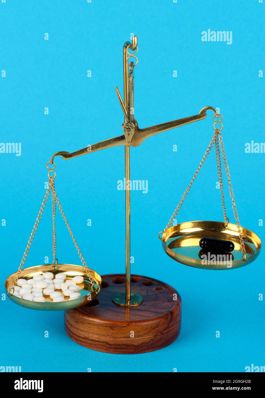 Classic scales with color pills on color background Stock Photo - Alamy