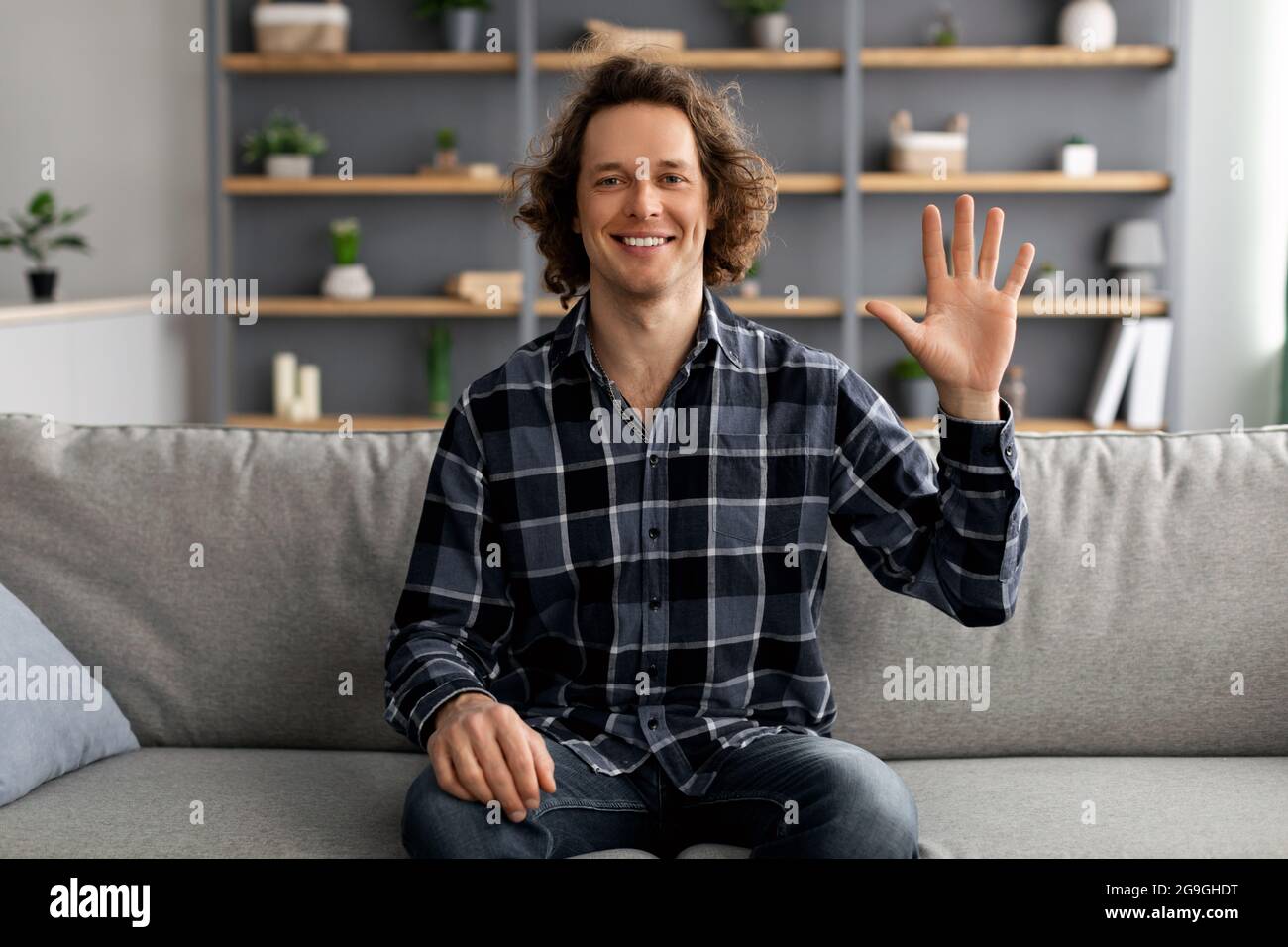 Positive Man Waving Hello In Greeting Gesture Smiling To Camera Posing ...