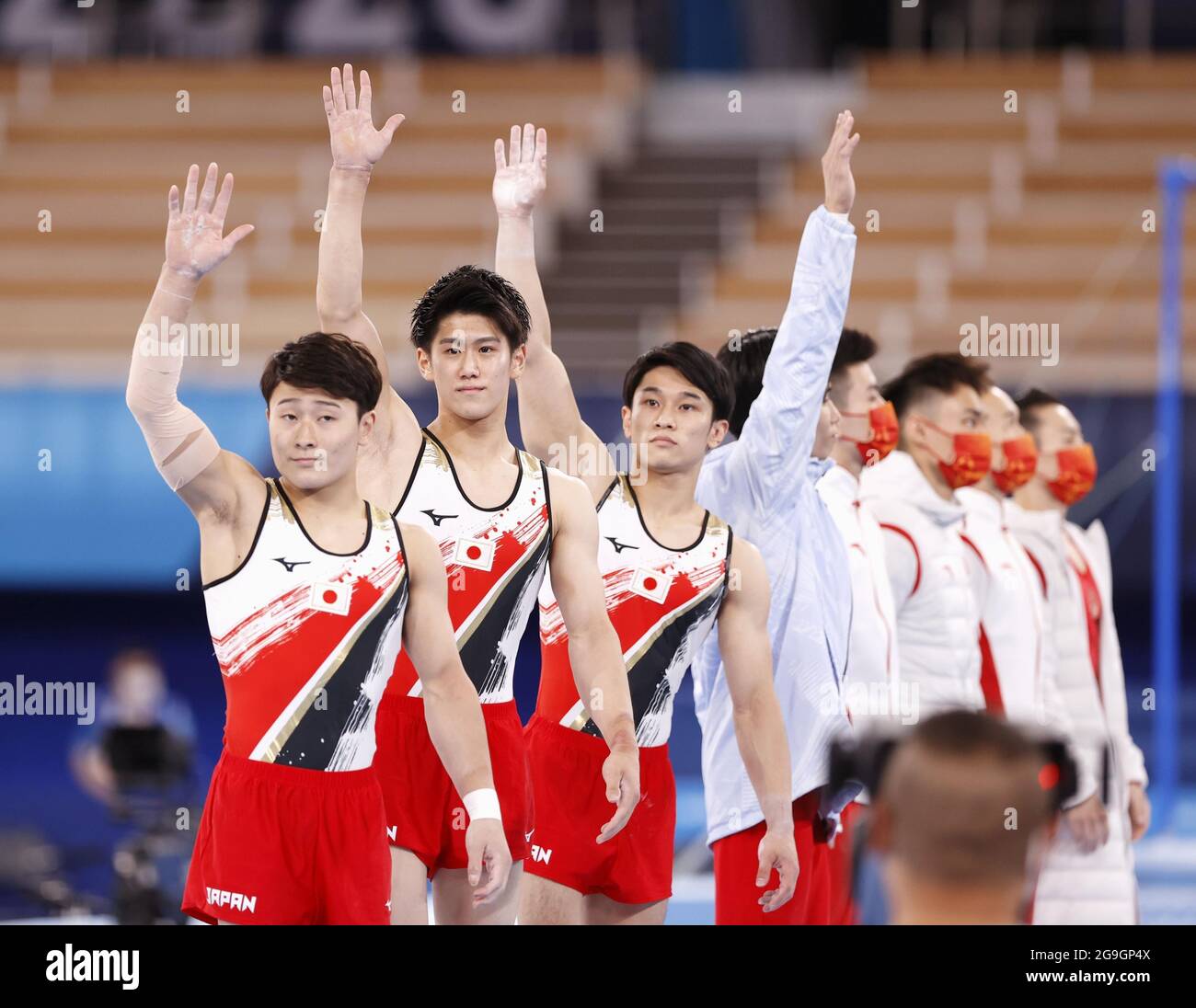 Gymnasts of Japan (L) and China line up prior to the men's team final ...
