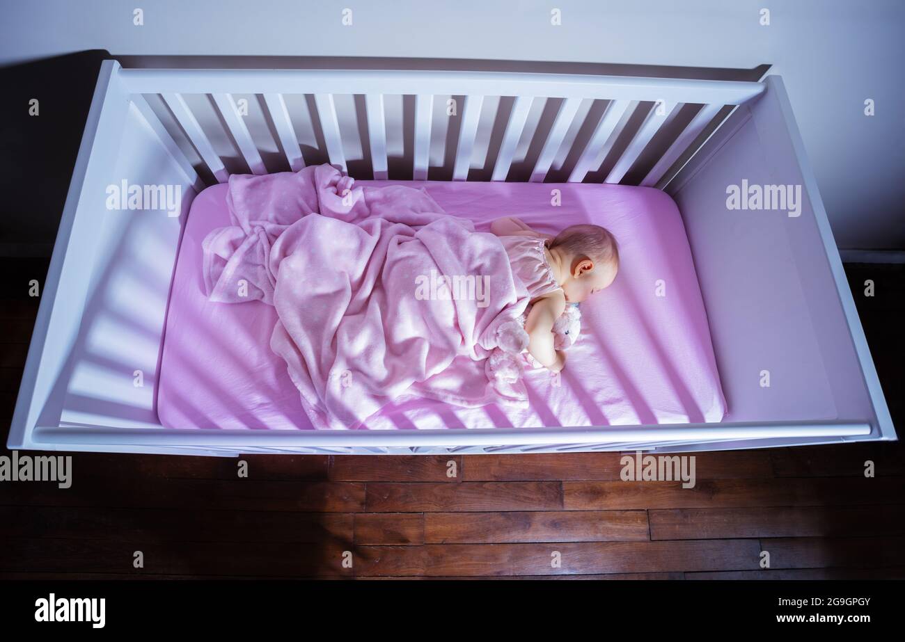 Crib bed view from above with little baby girl Stock Photo - Alamy