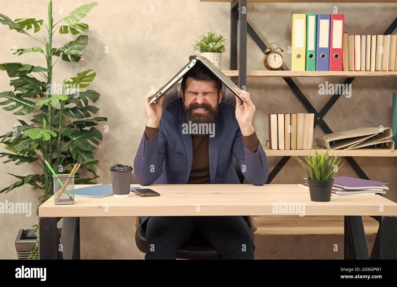 Distressed businessman hold laptop computer on head suffering from ...