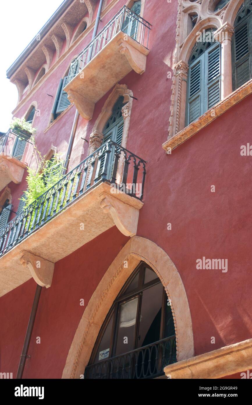 Close-up of a very ornate arched window with shutters on an old Italian ...