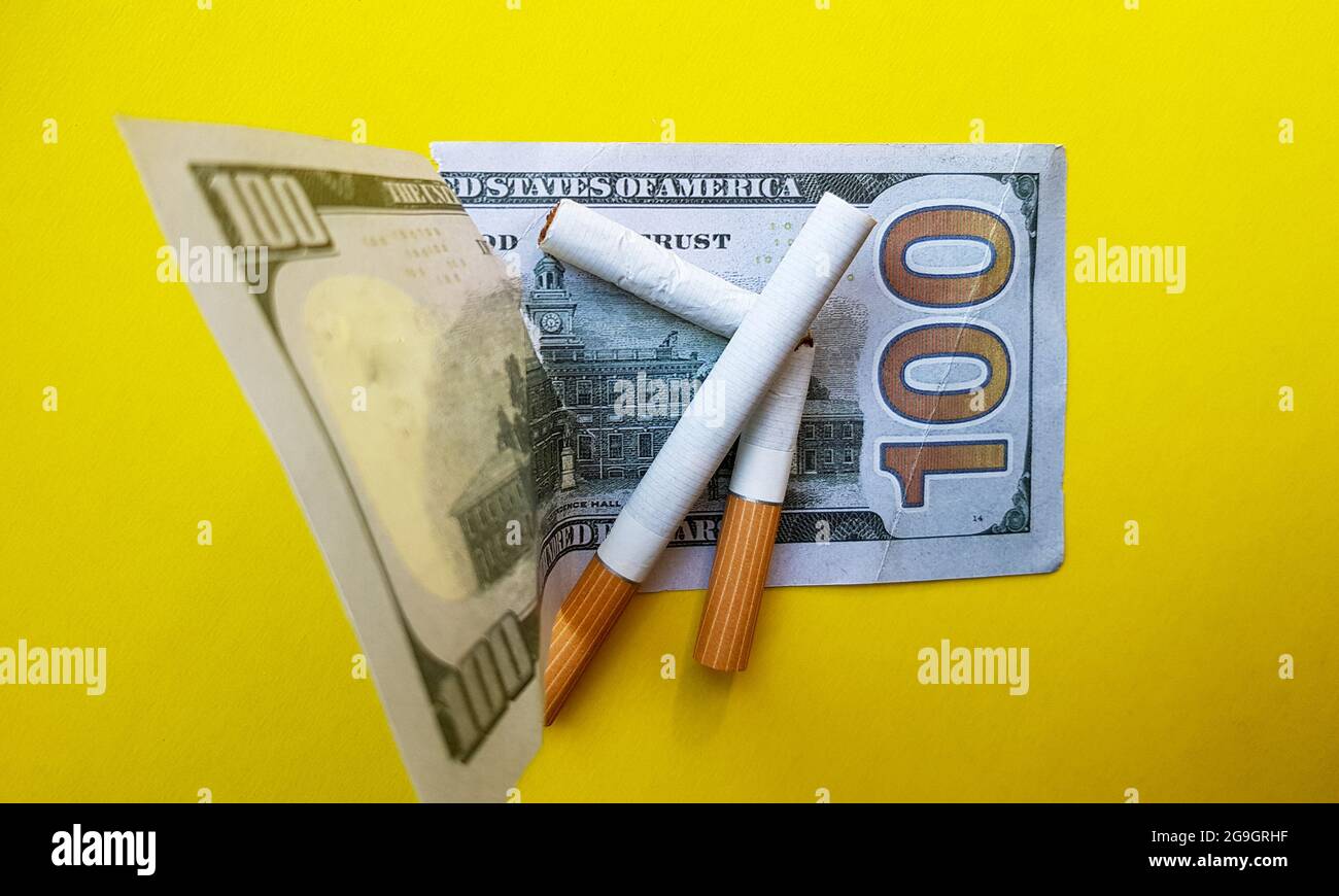 Classic cigarettes stand on one hundred US dollar bills. Cigarettes on ...