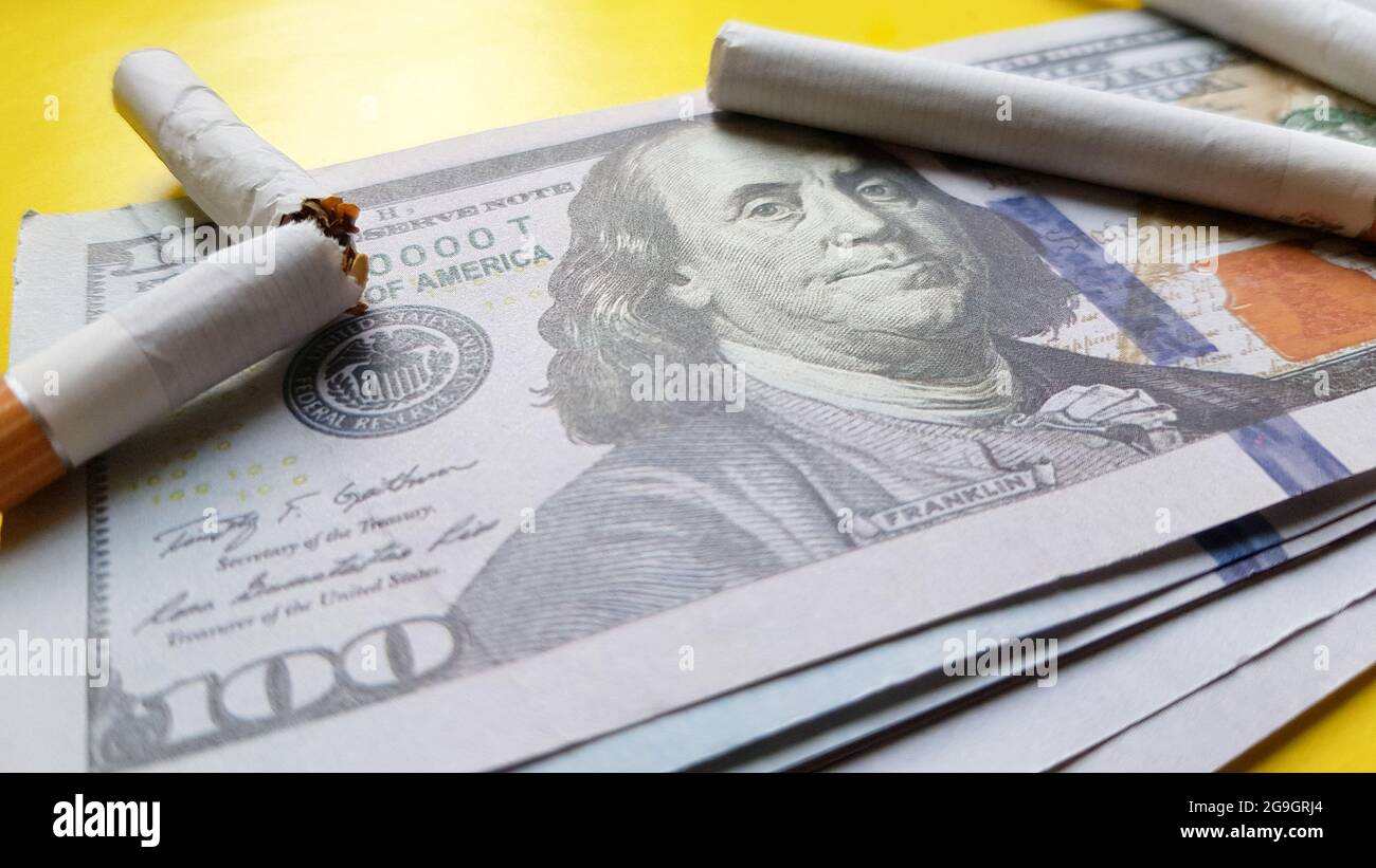 Classic cigarettes stand on one hundred US dollar bills. Cigarettes on ...