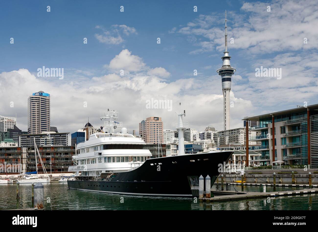 Viaduct Harbour; large yacht; boats docked, Sky Tower, cityscape ...