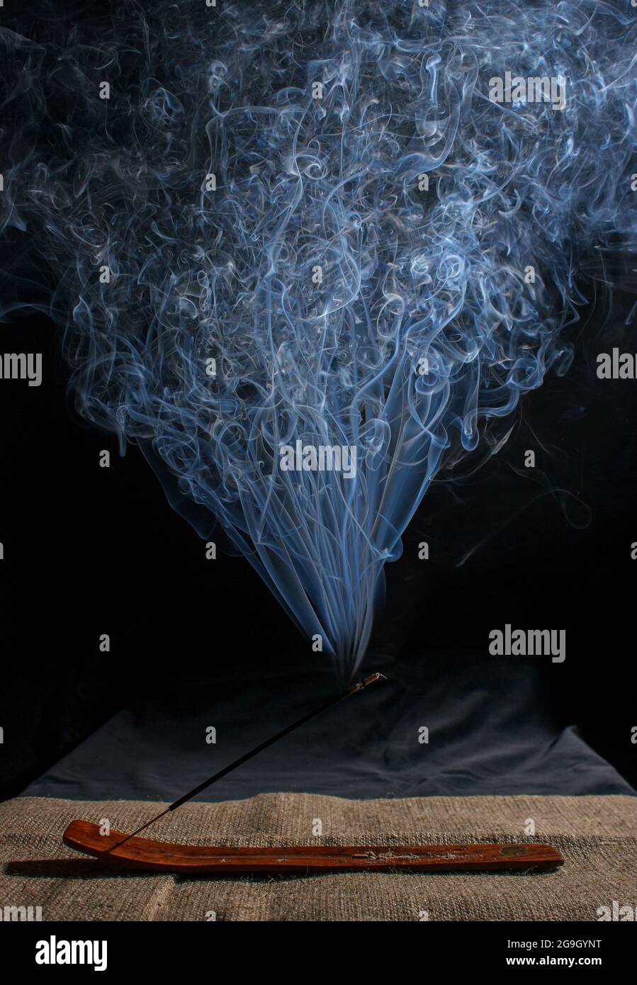 indian incense stick with smoke on black background indoor closeup ...