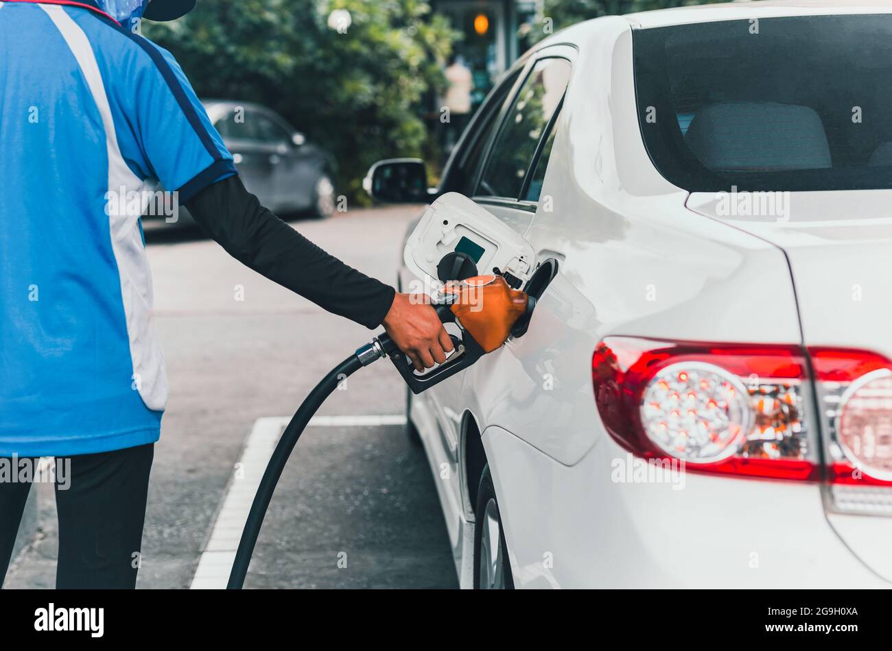 Employee putting nozzle into tank and refueling car with gasoline Stock ...