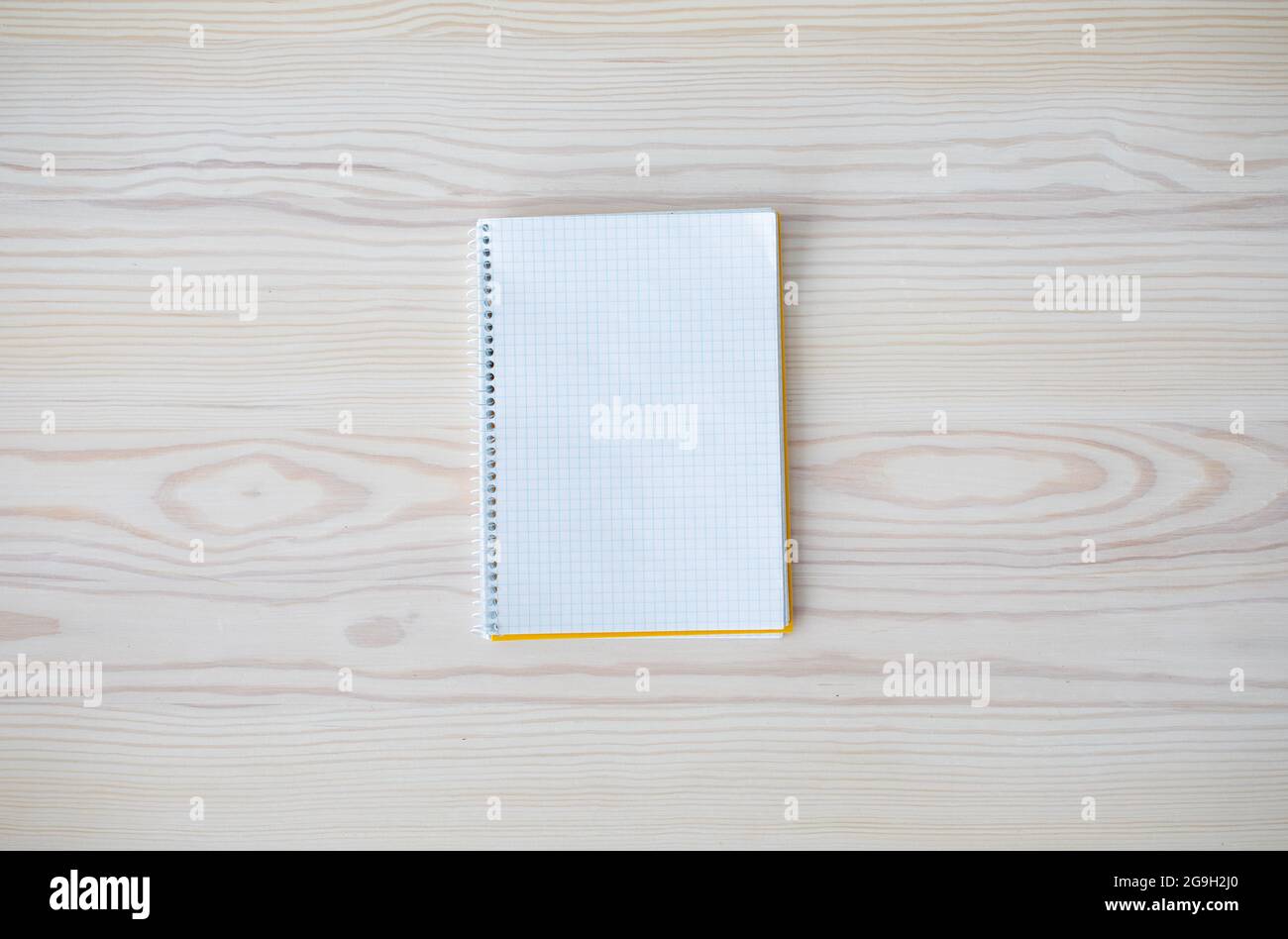Empty white spiral notepad as mockup for your design on wooden table ...
