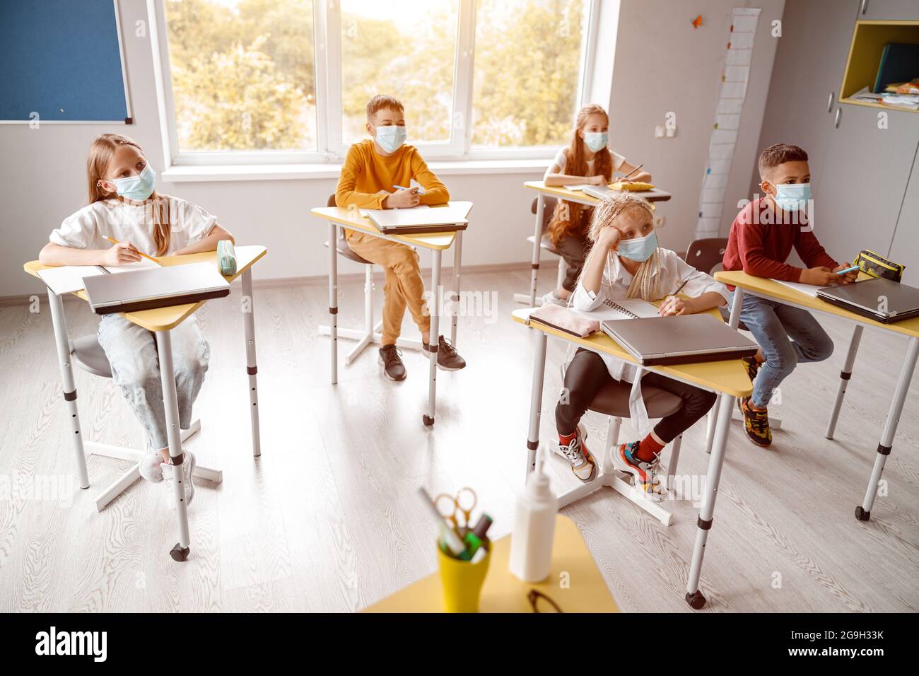 School kids with notebooks sitting in classroom together Stock Photo ...