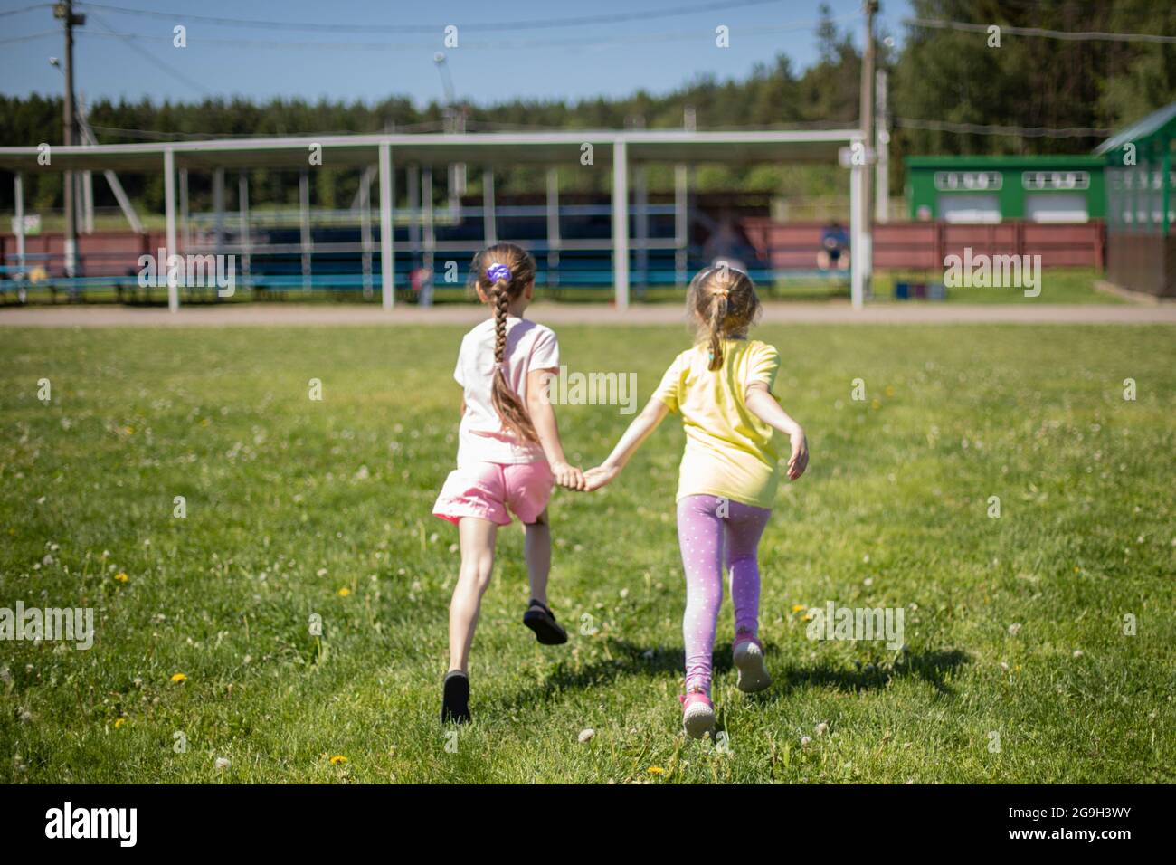 The children held hands and ran. Children run on the lawn. Girls are in ...