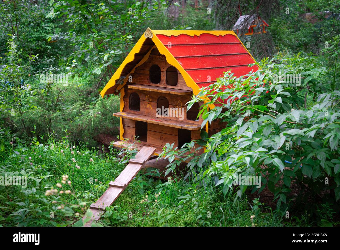 a wooden house for homeless cats stands in the park among the trees ...