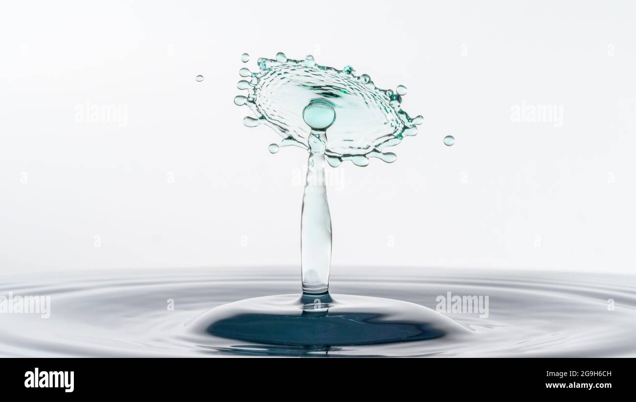 Close-up photograph of two water droplets colliding making an unusual ...