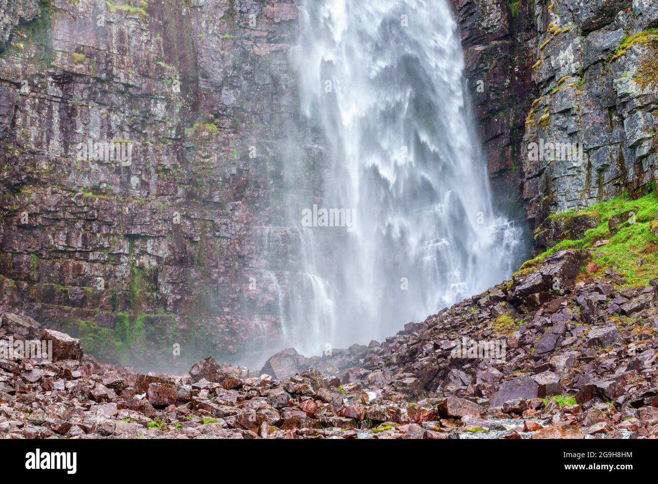 Waterfall with water spray at a rock face Stock Photo - Alamy