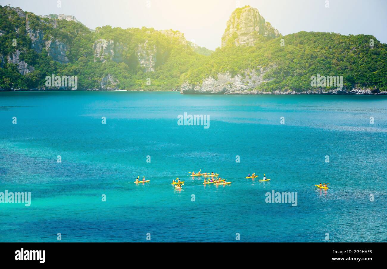 Aerial view of tourists kayaking on the blue sea with green island ...