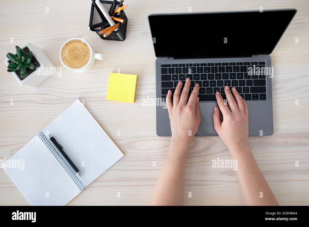 Workplace. Woman typing on laptop computer keyboard and writing notes ...