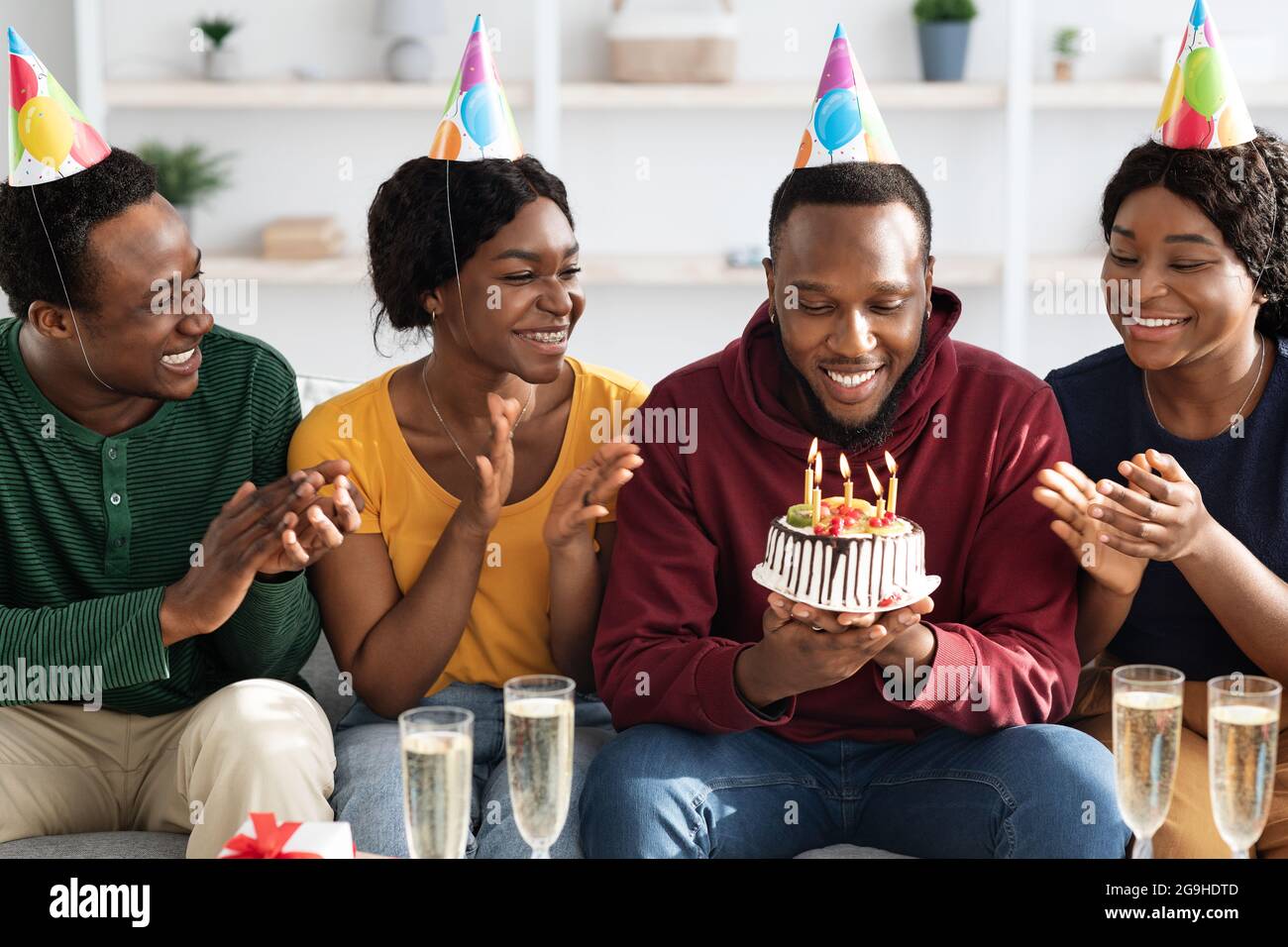 Cheerful millennial black friends greeting birthday guy, making home ...