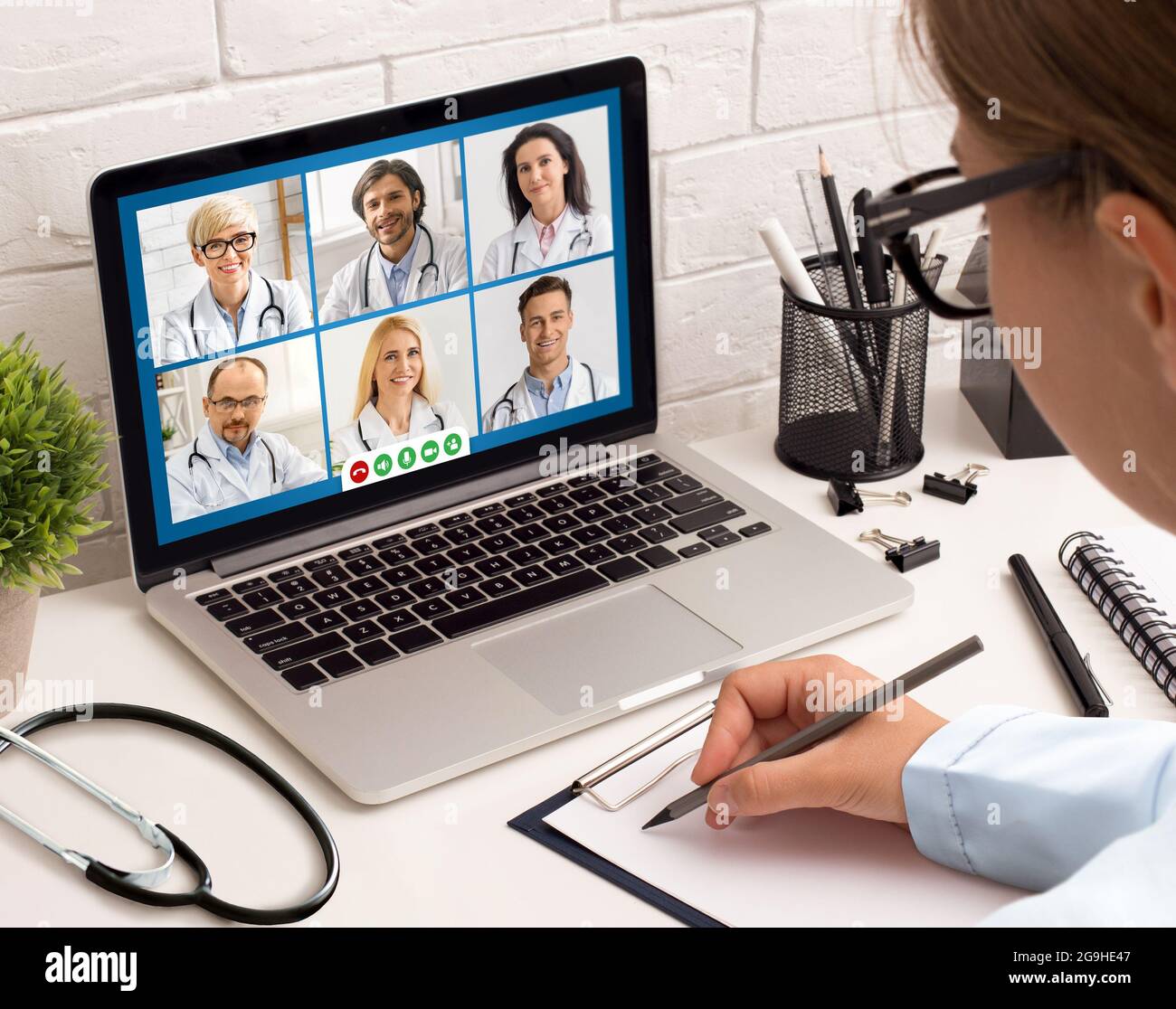 Female Doctor Having Virtual Meeting With Colleagues Via Video Call On ...