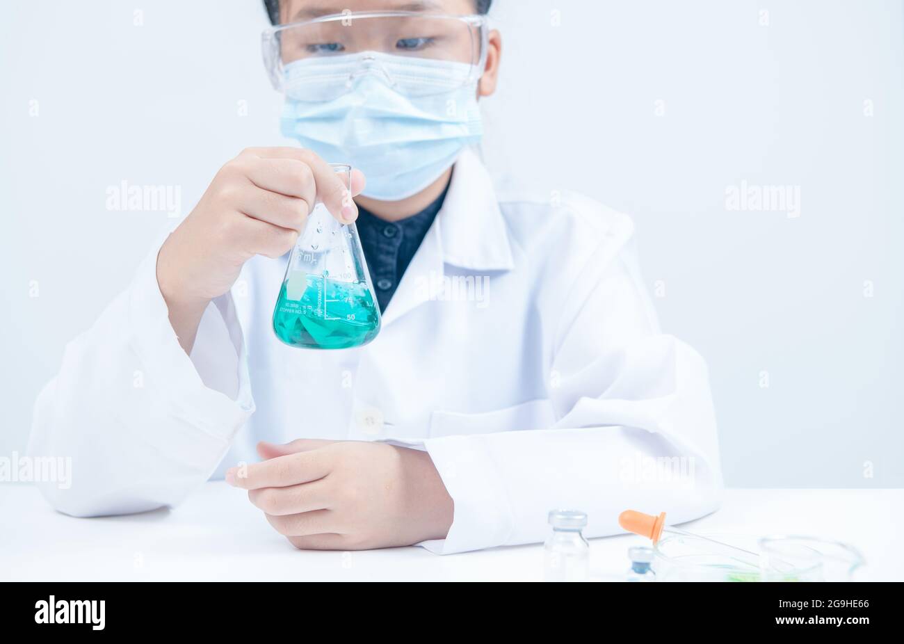 Young Scientists shaking blue liquid chemical in Erlenmeyer flask ...