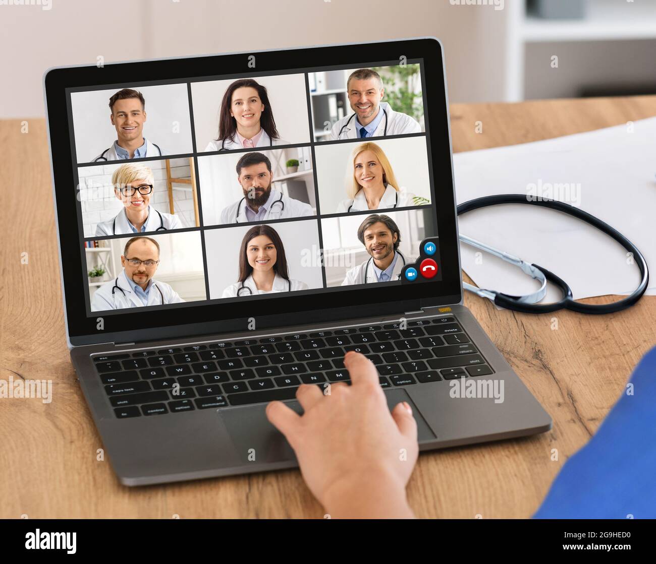 Female Doctor At Laptop Video Calling Communicating With Group Of ...