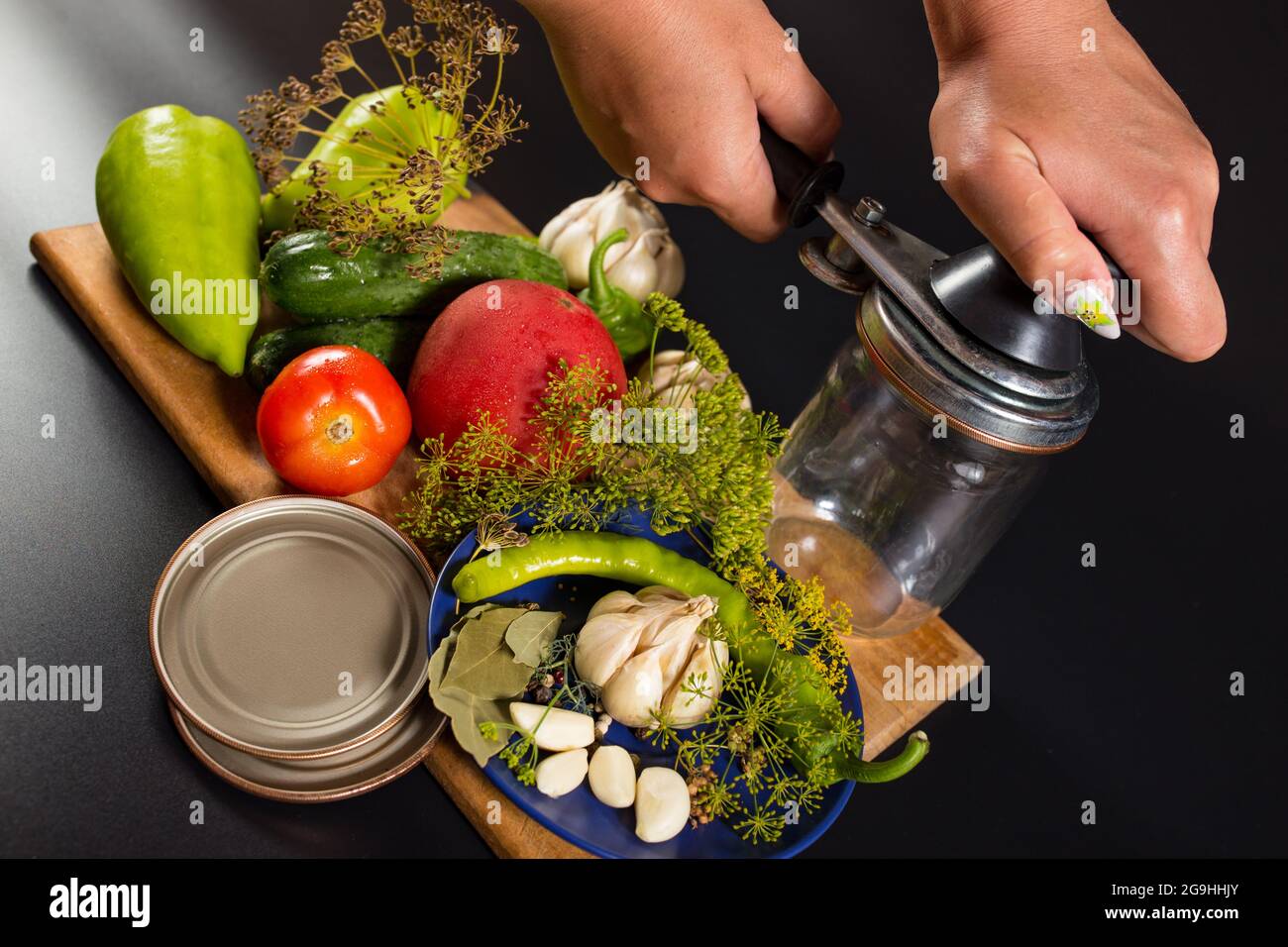 Woman hands doing canning with canning tool different vegetables and ...