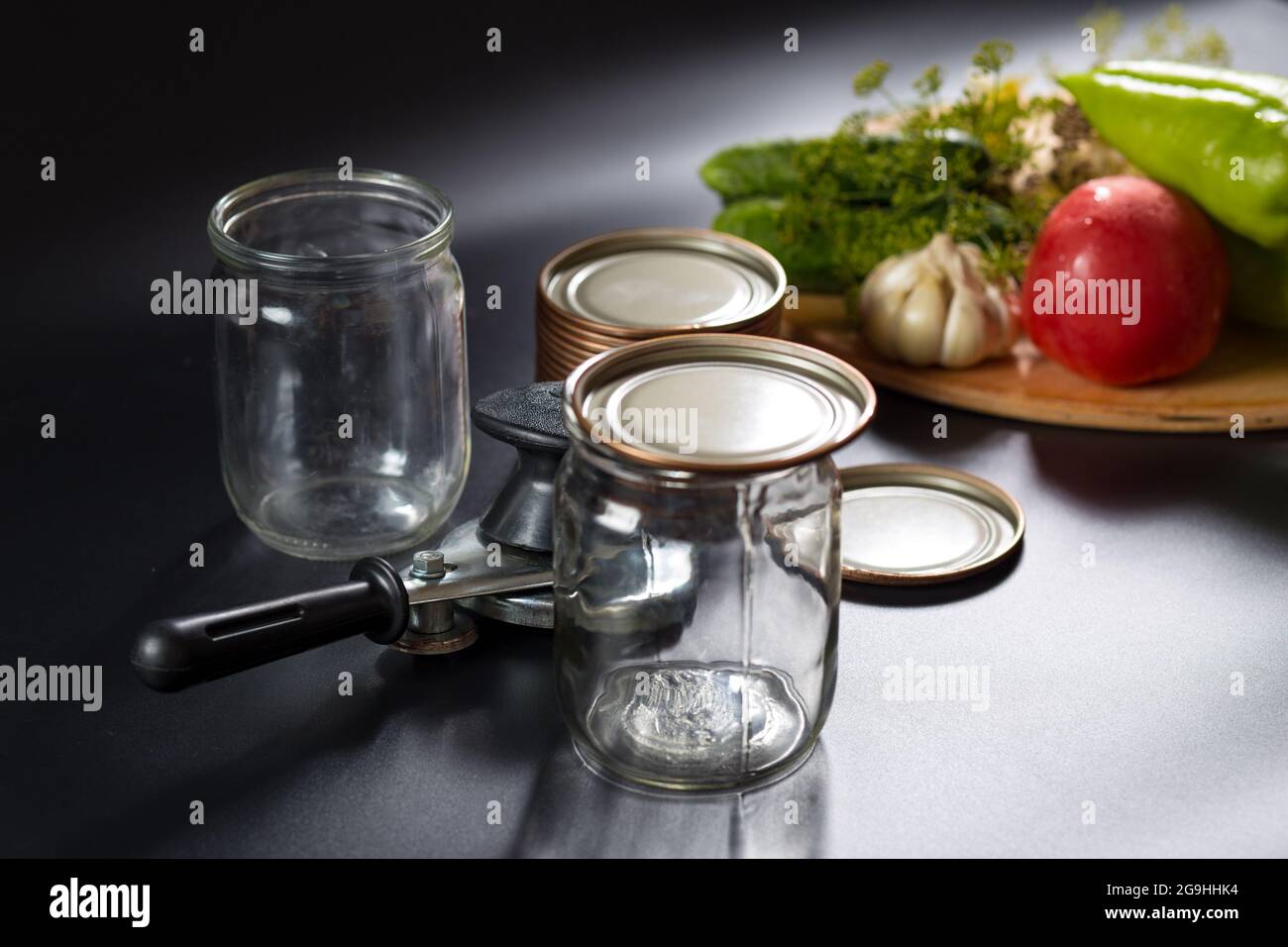 Vegetables for canning on background and canning tool with glass jars ...
