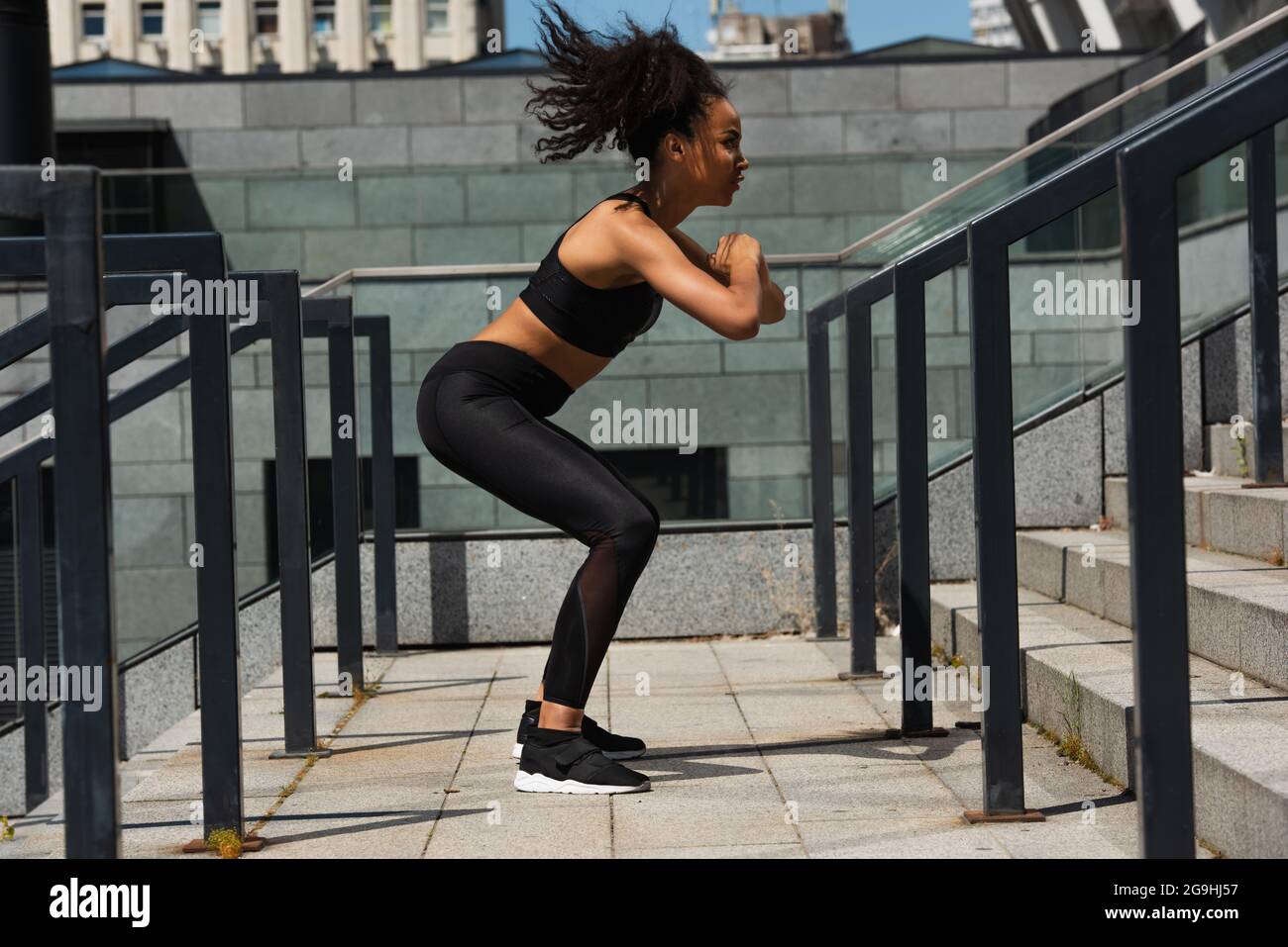 Side view of african american sportswoman trailing on stairs outdoors ...