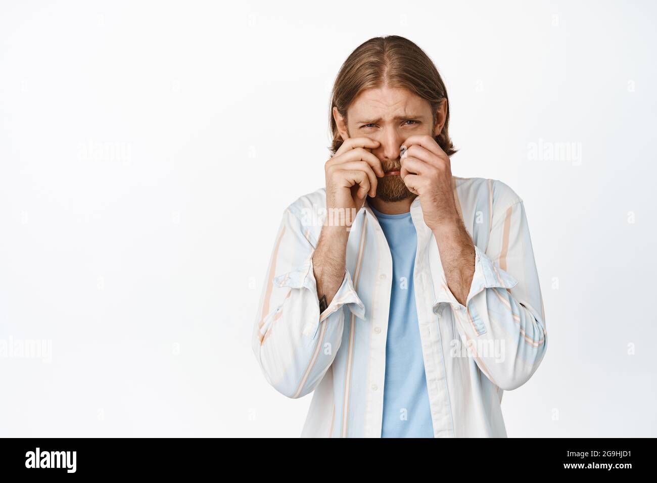 Portrait of silly and sad blond guy feeling timid, adult man crying and ...