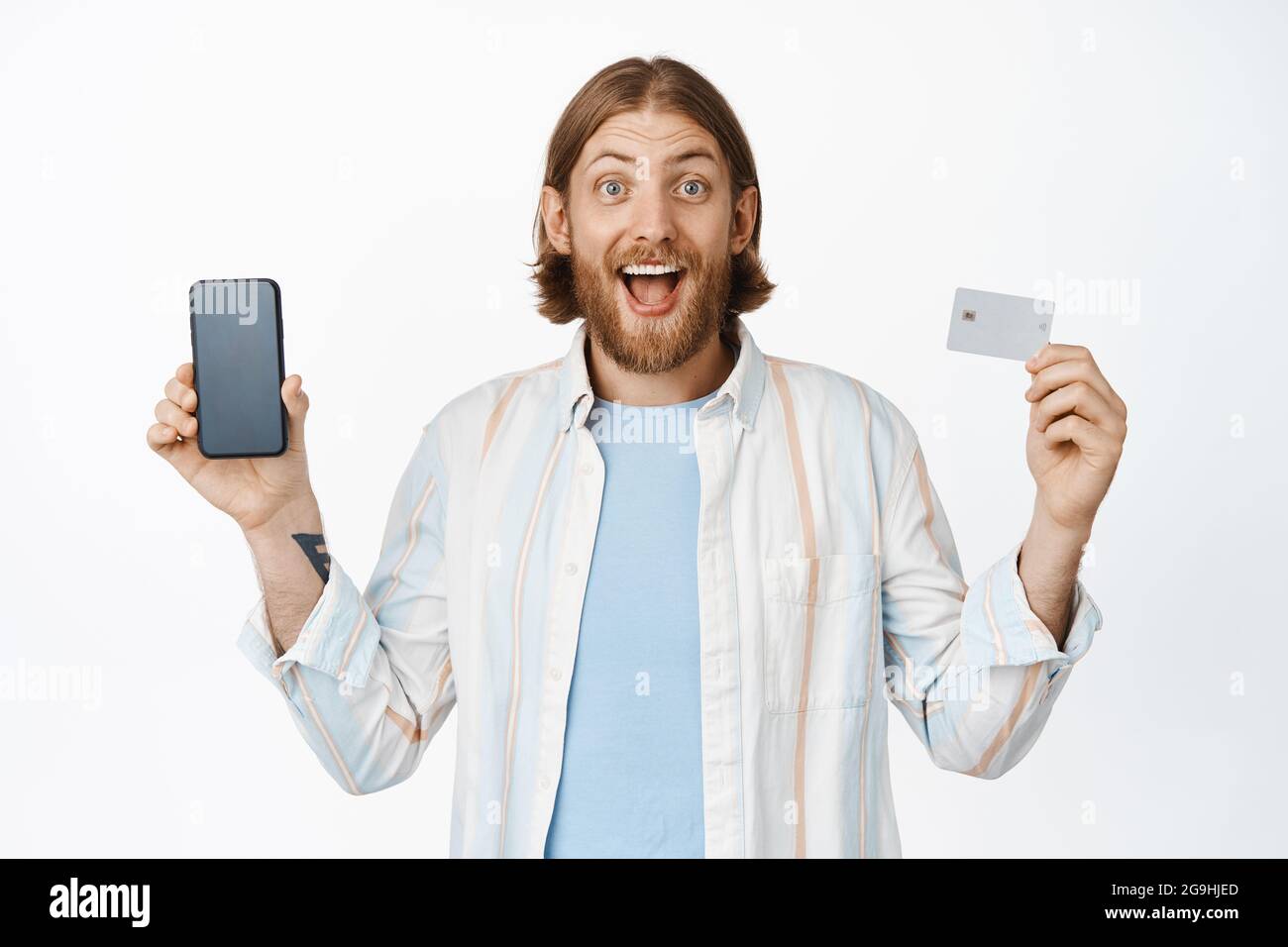 Online shopping. Happy blong guy showing credit card and smartphone ...